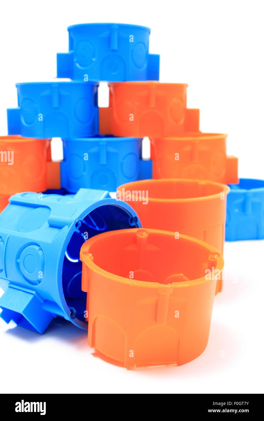 Blue and orange plastic electrical boxes on white background ...