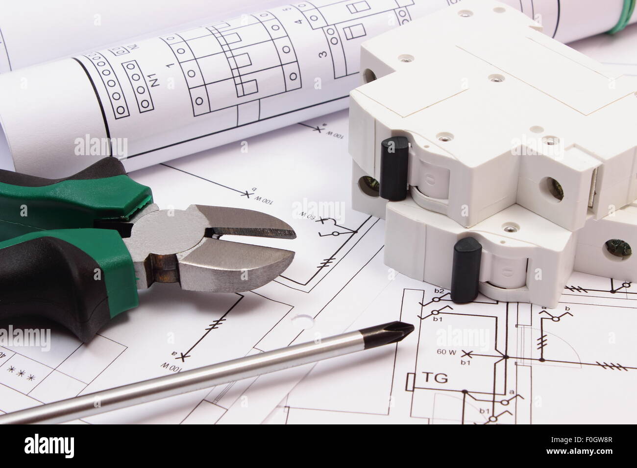 Metal pliers, screwdriver, electric fuse and rolls of diagrams on ...