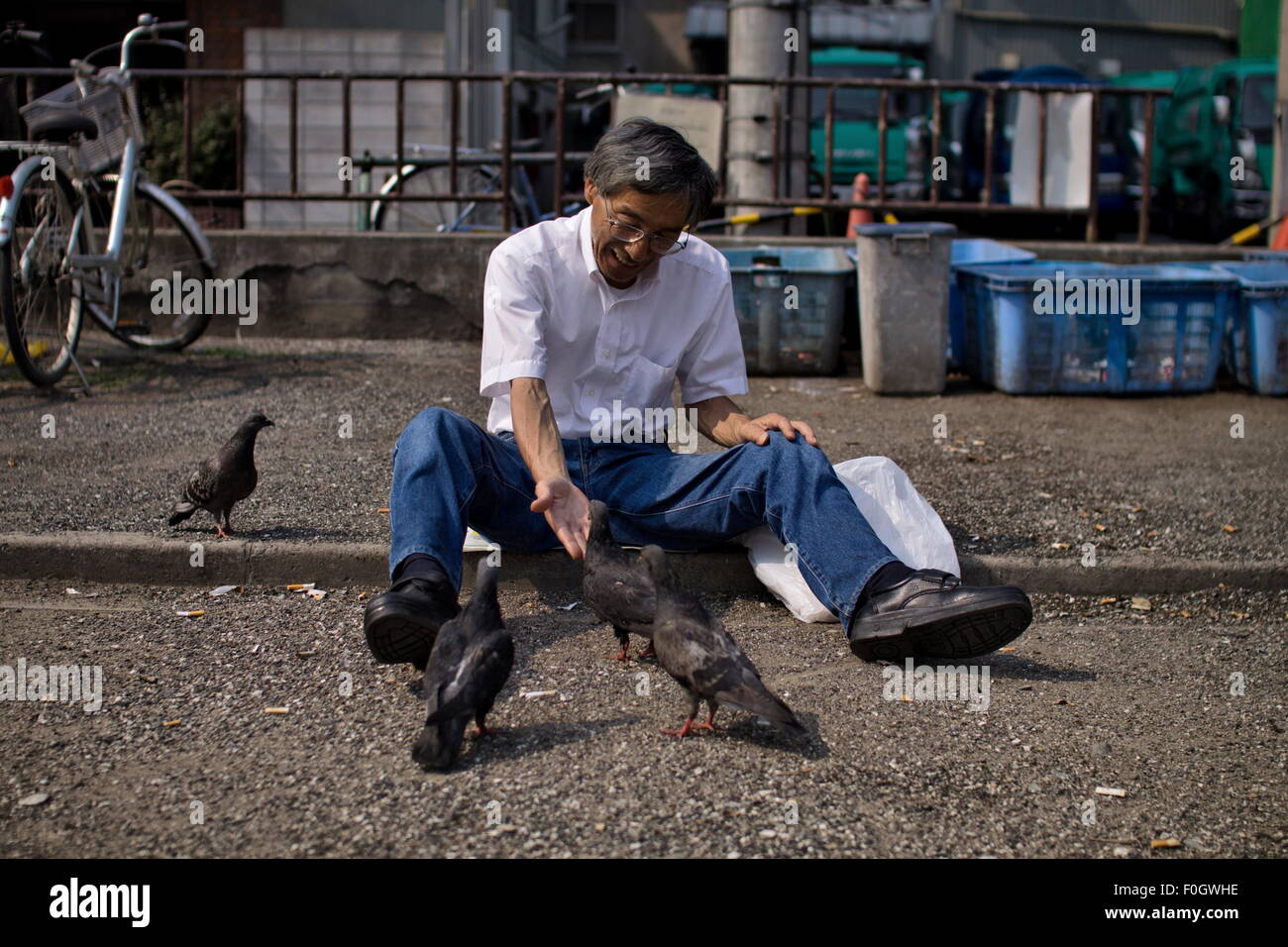 May 09, 2012 - Osaka, Japan - Man feed birds. City of Ghosts - A life ...