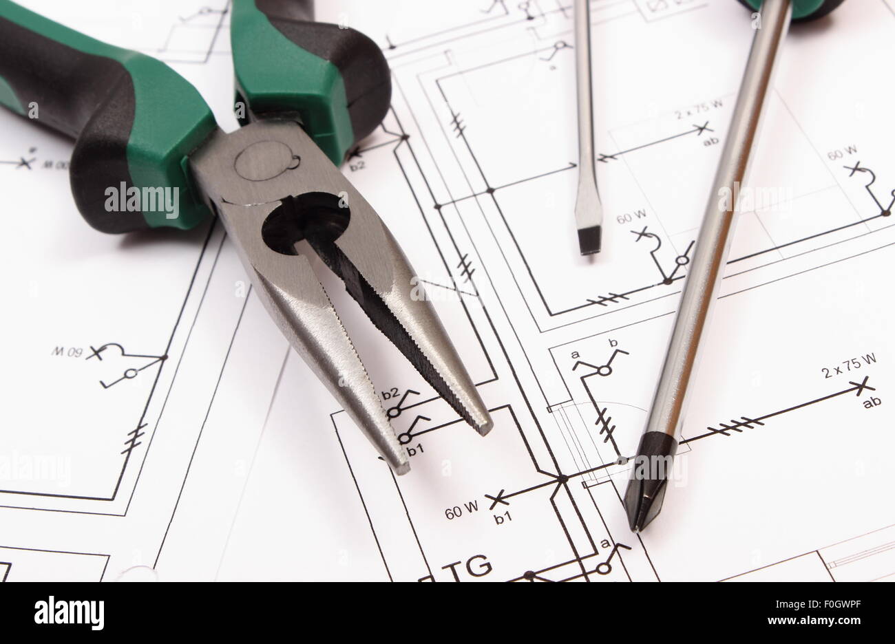 Metal pliers and screwdriver on electrical construction drawing of ...