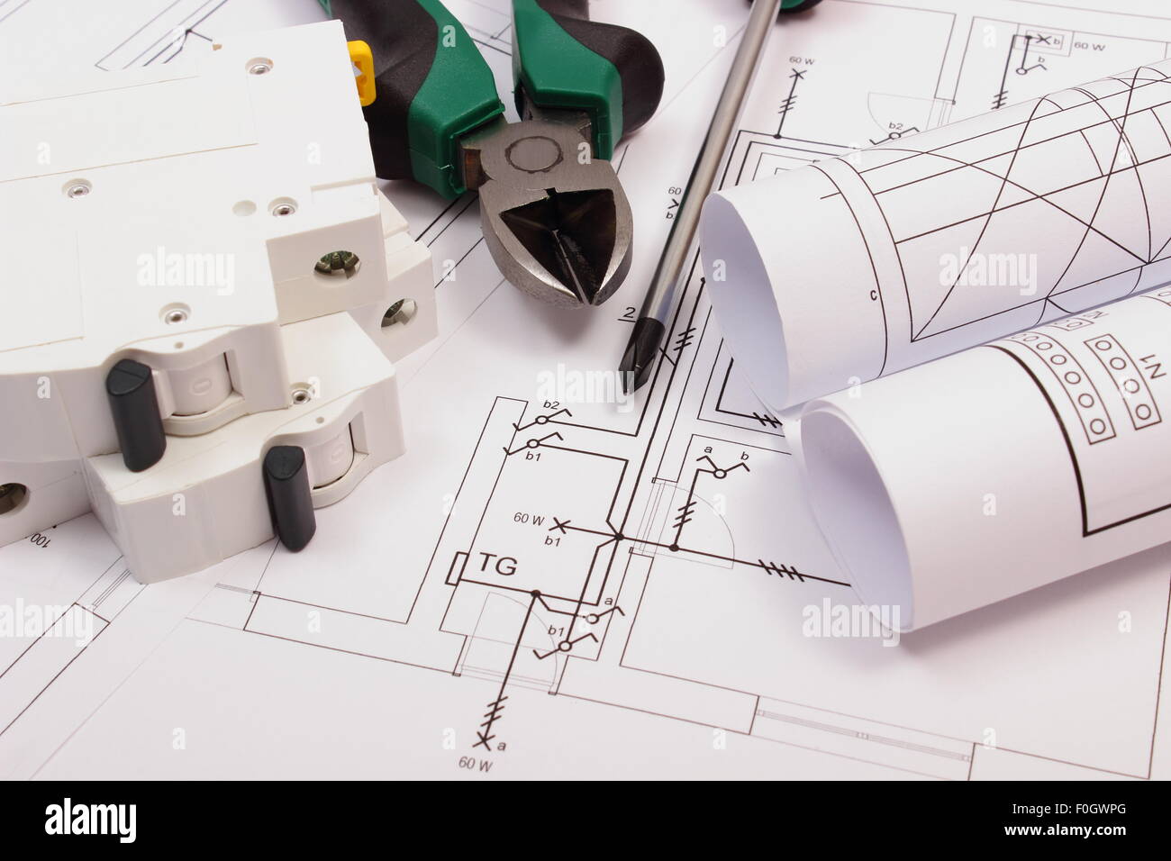 Metal pliers, screwdriver, electric fuse and rolls of diagrams on ...