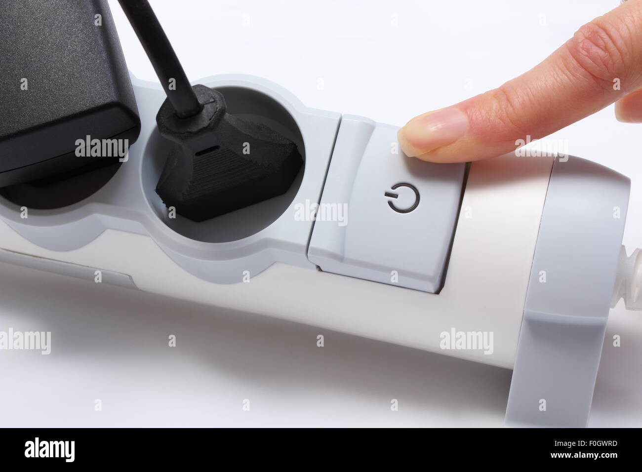 Finger of woman turns off electrical extension, electrical plugs with ...