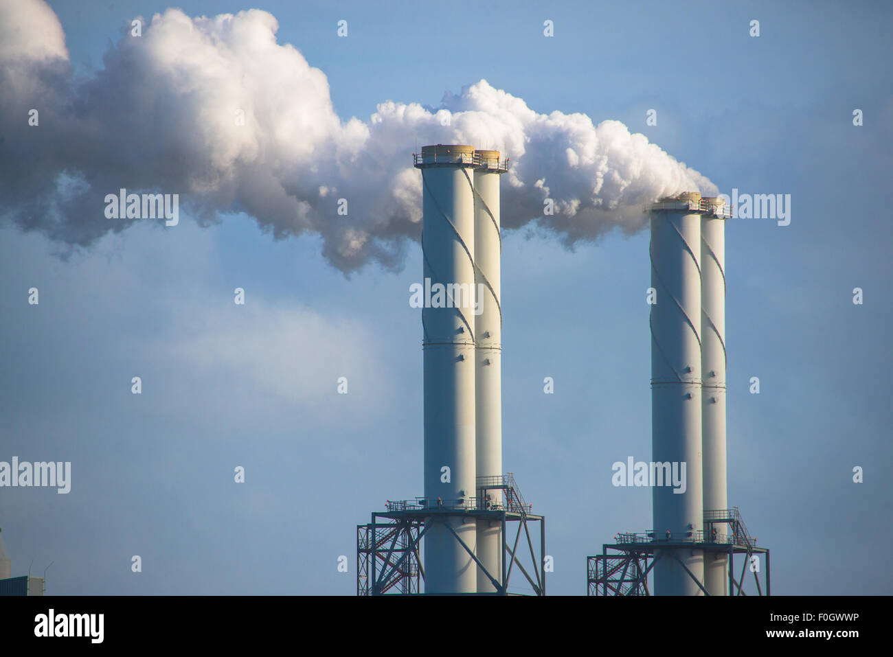 chimneys with smoke and blue sky Stock Photo - Alamy