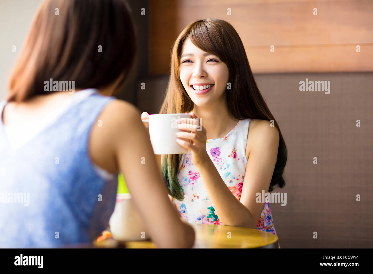 two young woman chatting in a coffee shop Stock Photo - Alamy