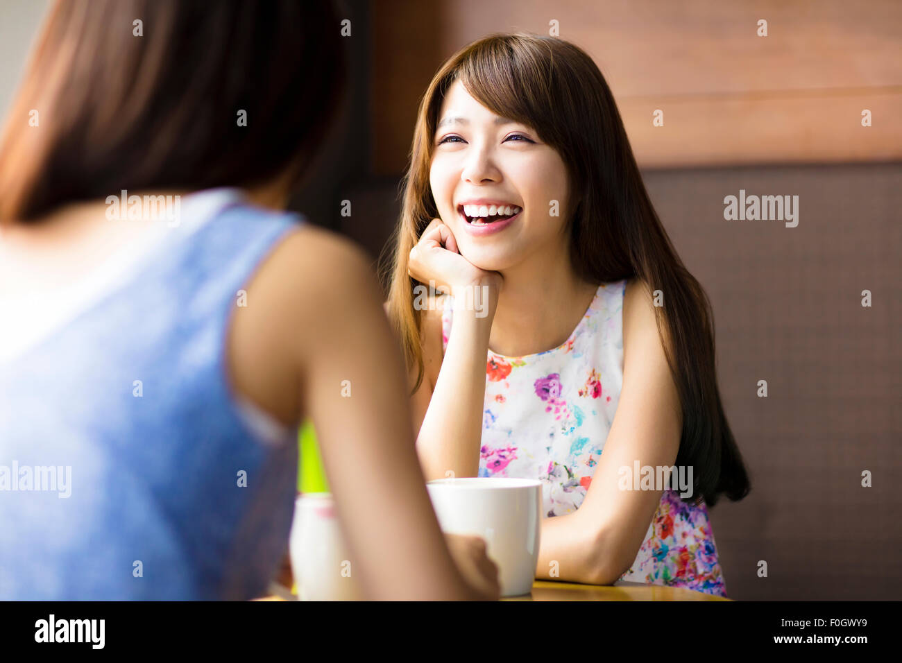 two young woman chatting in a coffee shop Stock Photo - Alamy