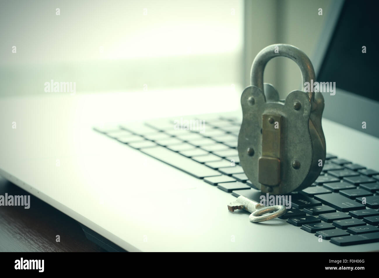 Internet security concept-old padlock and key on laptop computer ...