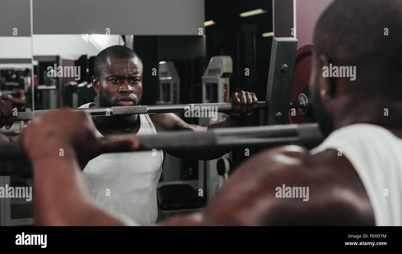 Weight training African doing bodybuilding in gym Stock Photo - Alamy