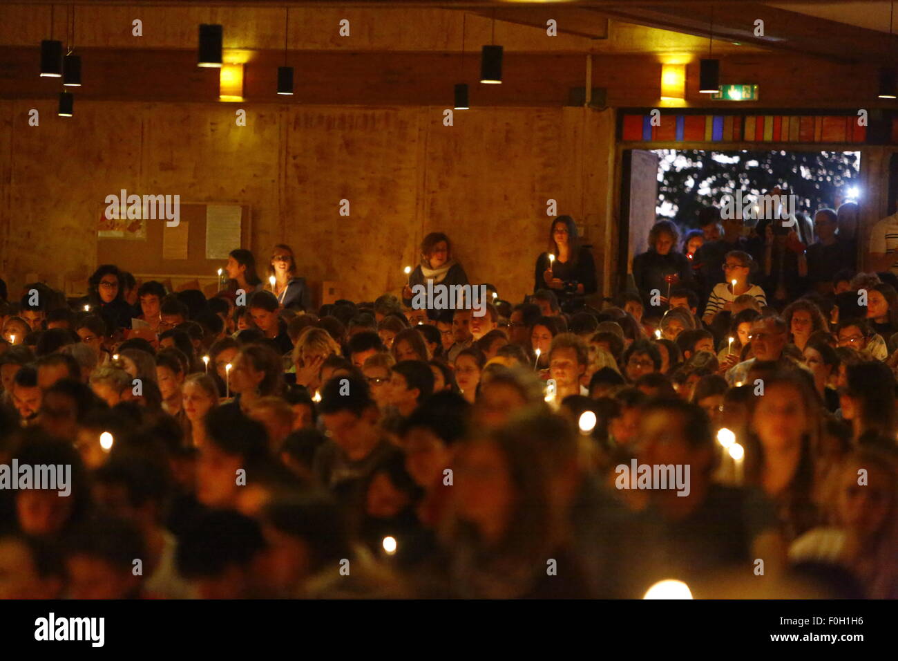 Taizé, France. 15th August 2015. Young pilgrims hold lit candles in ...