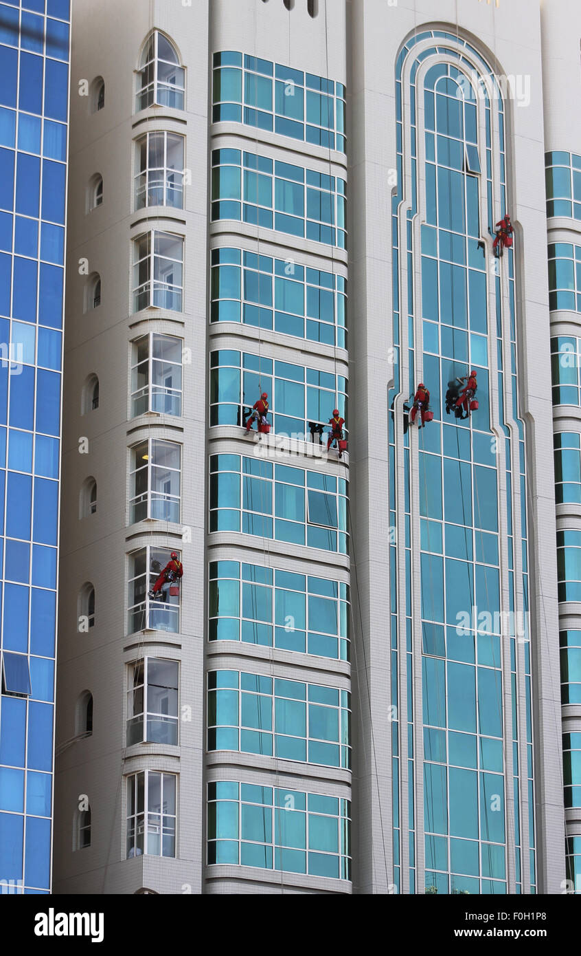 Window cleaners at work on a skyscraper using rds (rope descent system ...