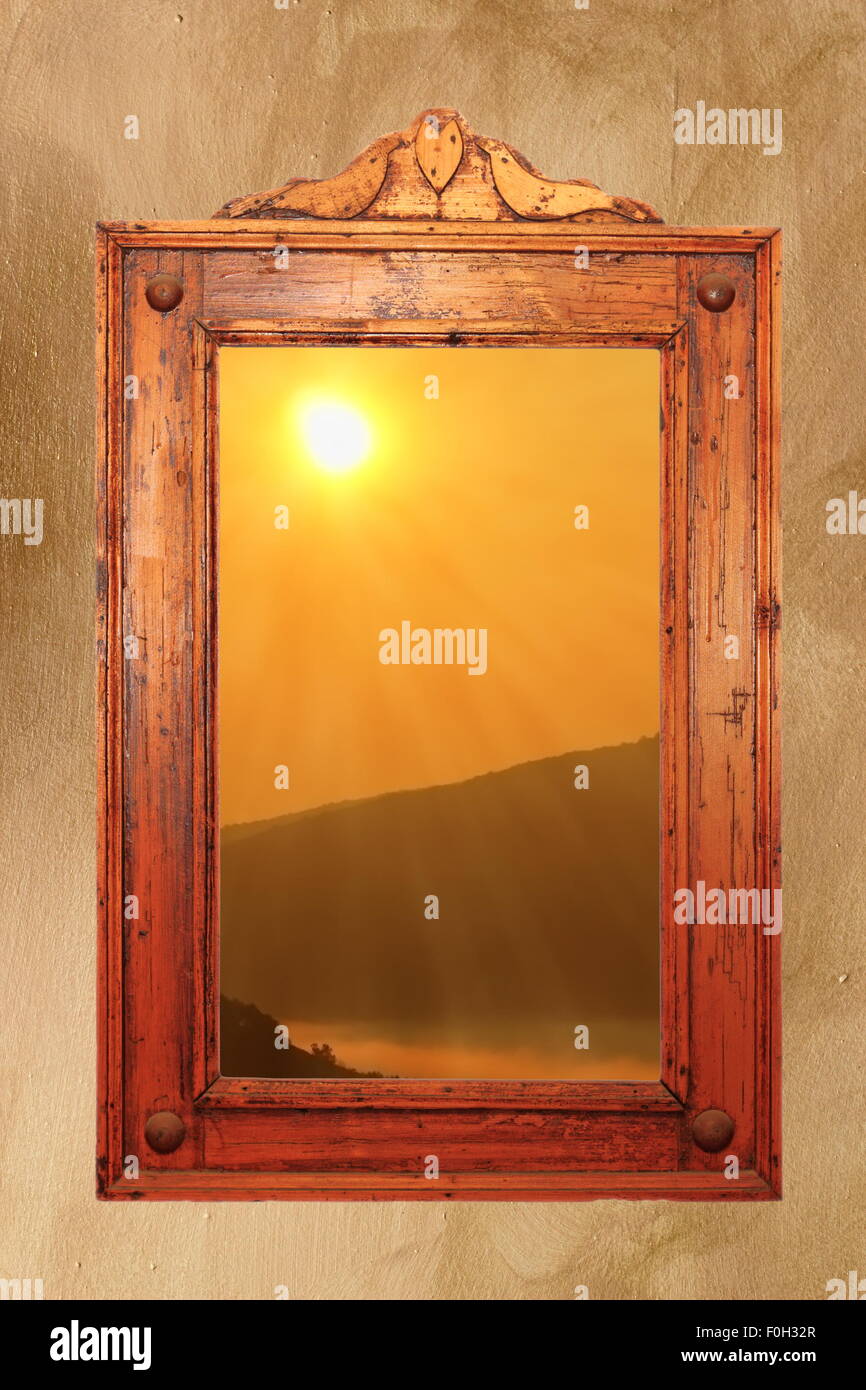 beautiful colors of sunrise seen through a window with old wooden frame ...