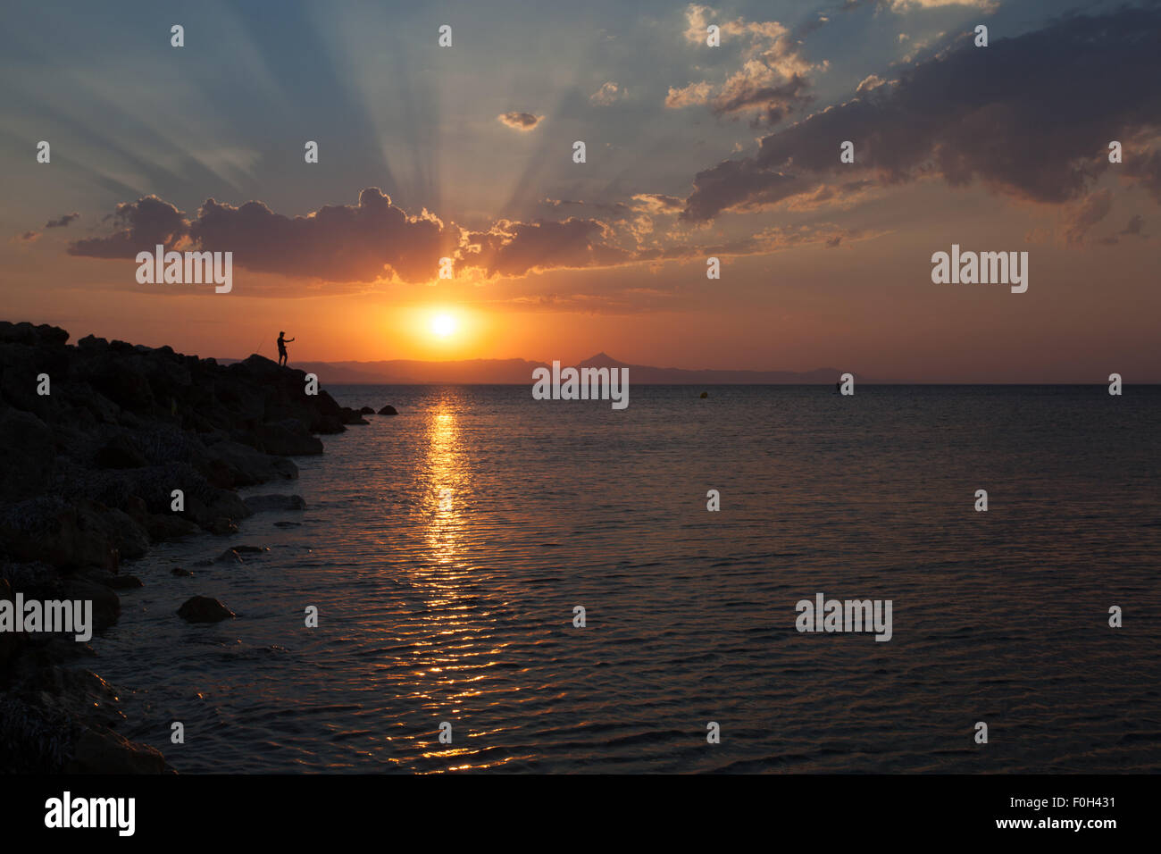 Sunset Selfie. Man standing on a rock taking a selfie of himself with a ...