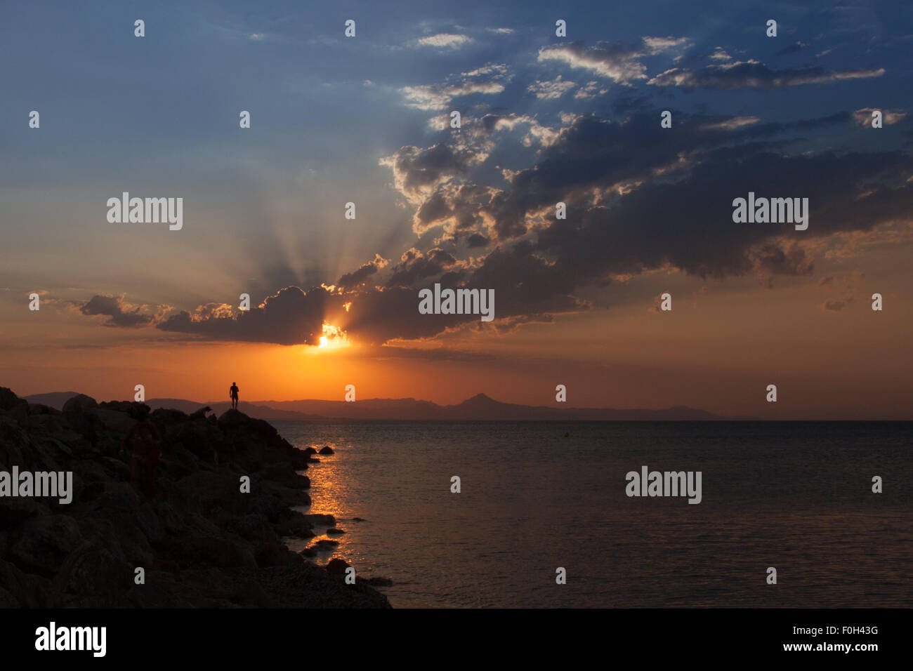 Silhouette of man standing on the beach watching sunset hi-res stock ...