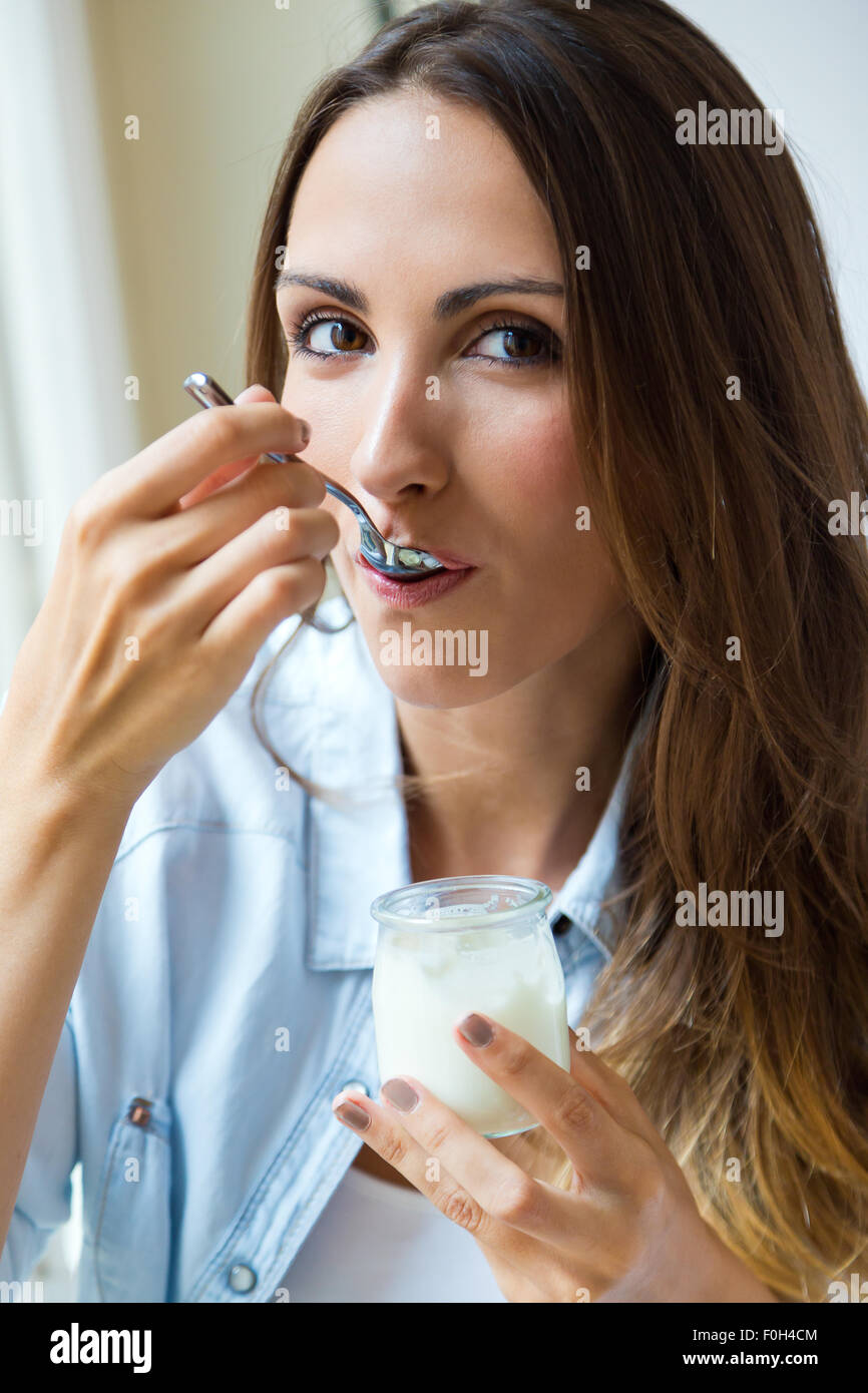Portrait of young woman at home eating yogurt Stock Photo - Alamy