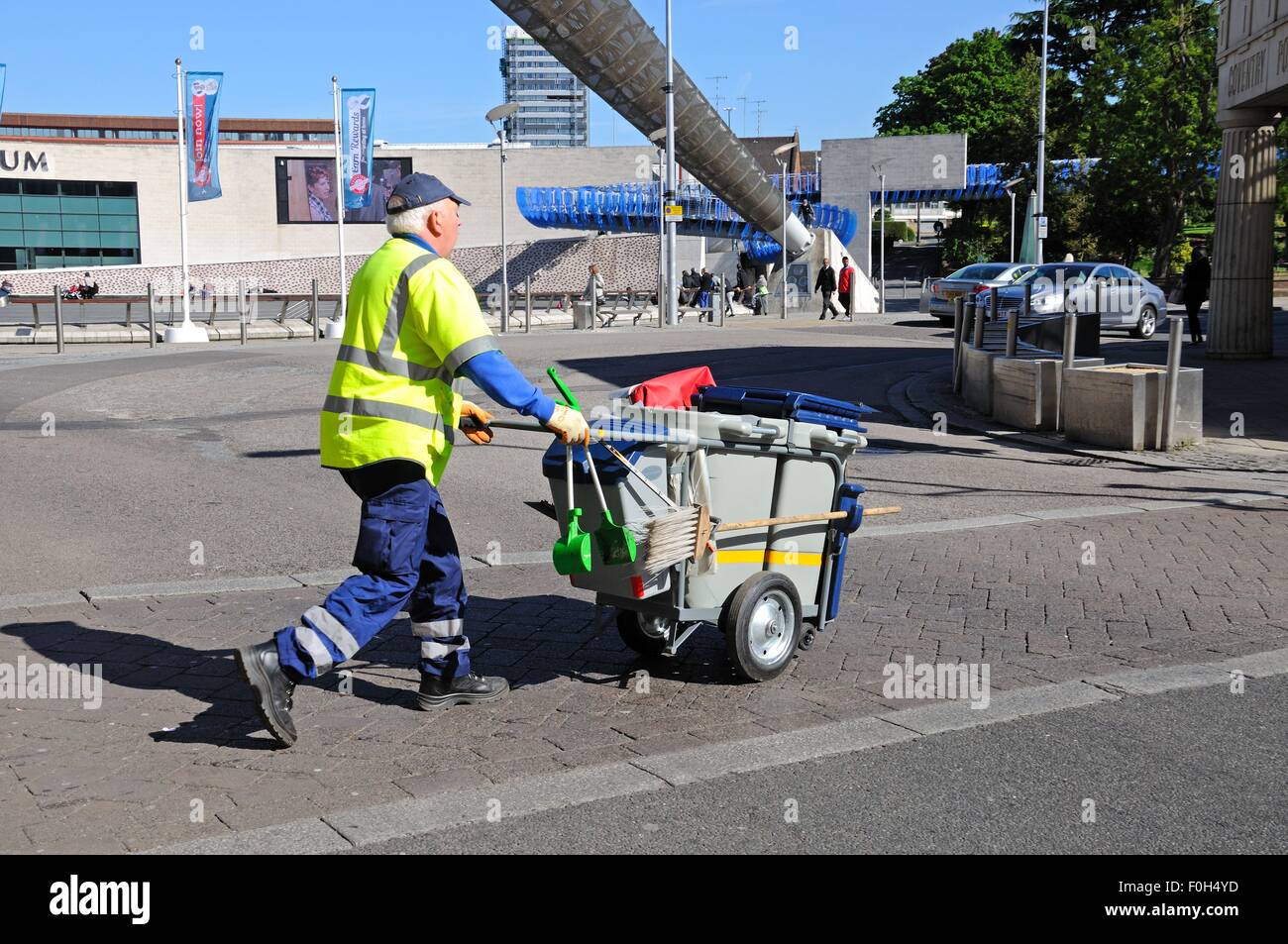 Rubbish collector pushing his trolley along the pavement at Millennium ...