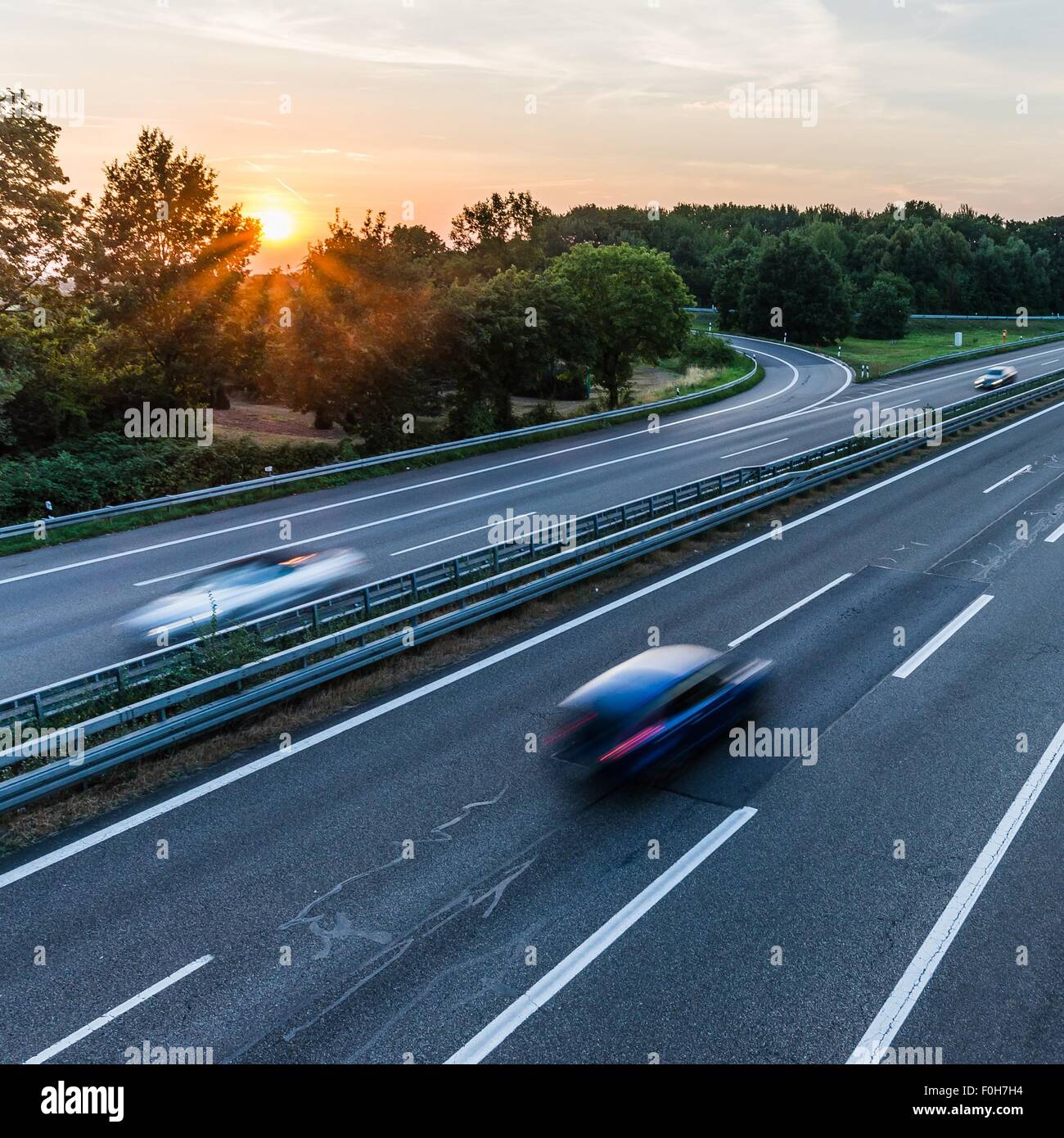 german highway at sunset with light trails from passing cars Stock ...