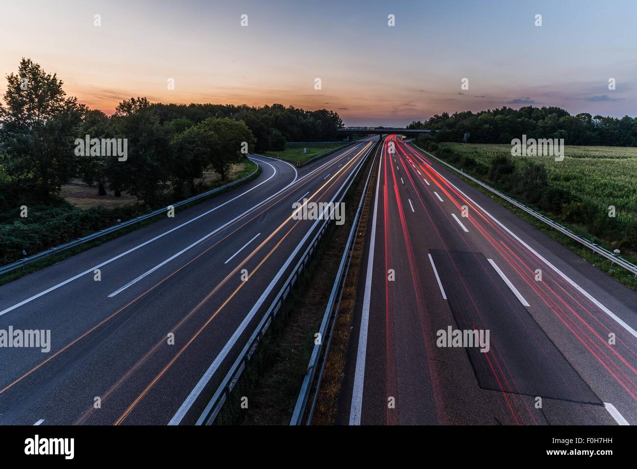 german highway at sunset with light trails from passing cars Stock ...