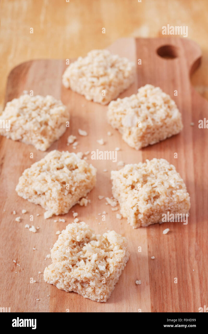 Coconut candy cocada on wooden board. Selective focus on first piece ...