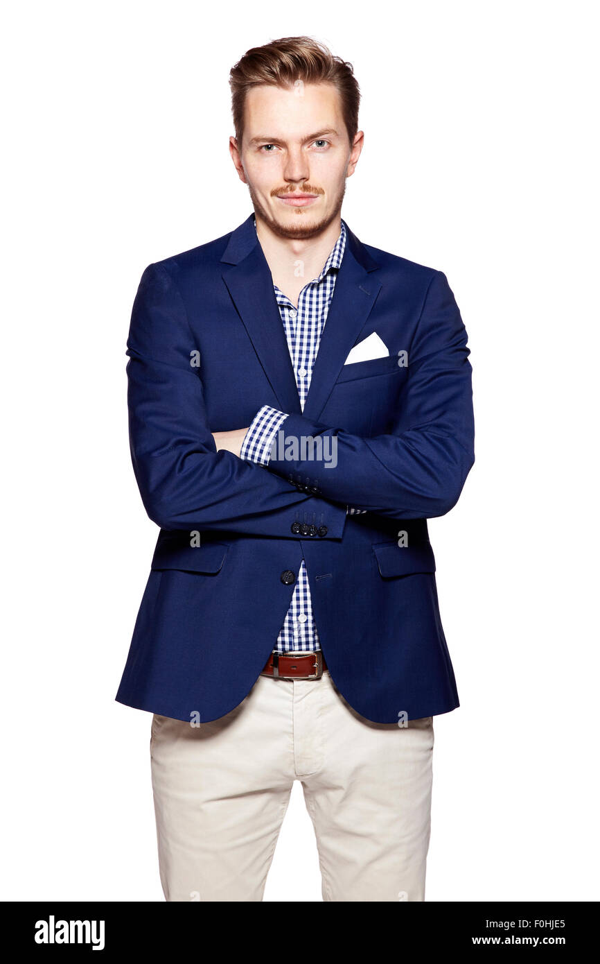 Portrait of a serious young man standing isolated against white ...