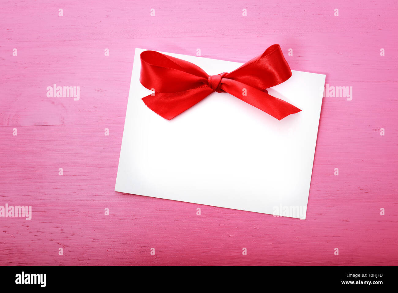 Blank message card with red ribbon on pink wooden board Stock Photo - Alamy