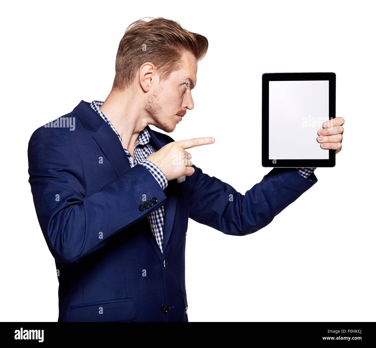 Studio shot of a young man pointing at digital tablet. Isolated on ...