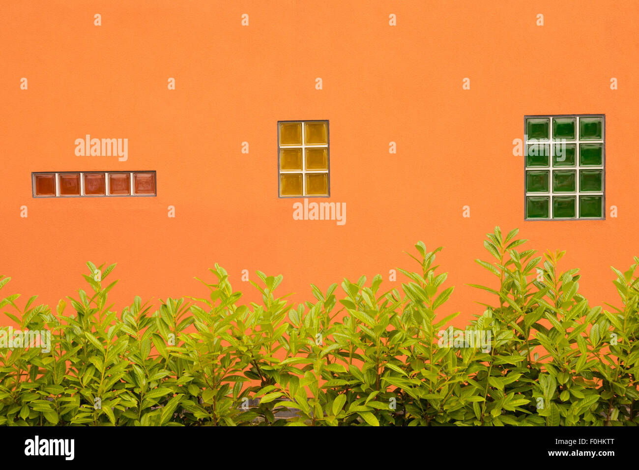 Modern building wall painted in a bright colour, with small glass block ...