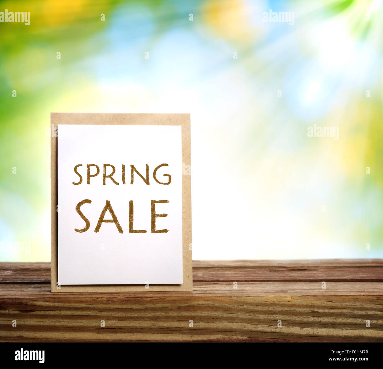 Spring Sale sign on rustic wooden board over shiny green background ...