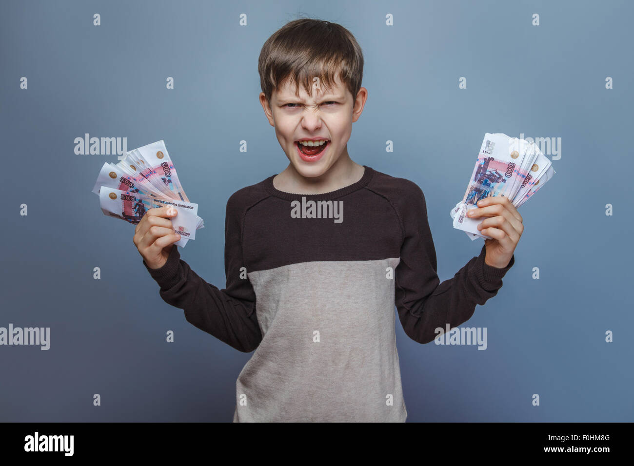 Boy teenager ten years European appearance holding a wad of mo Stock ...
