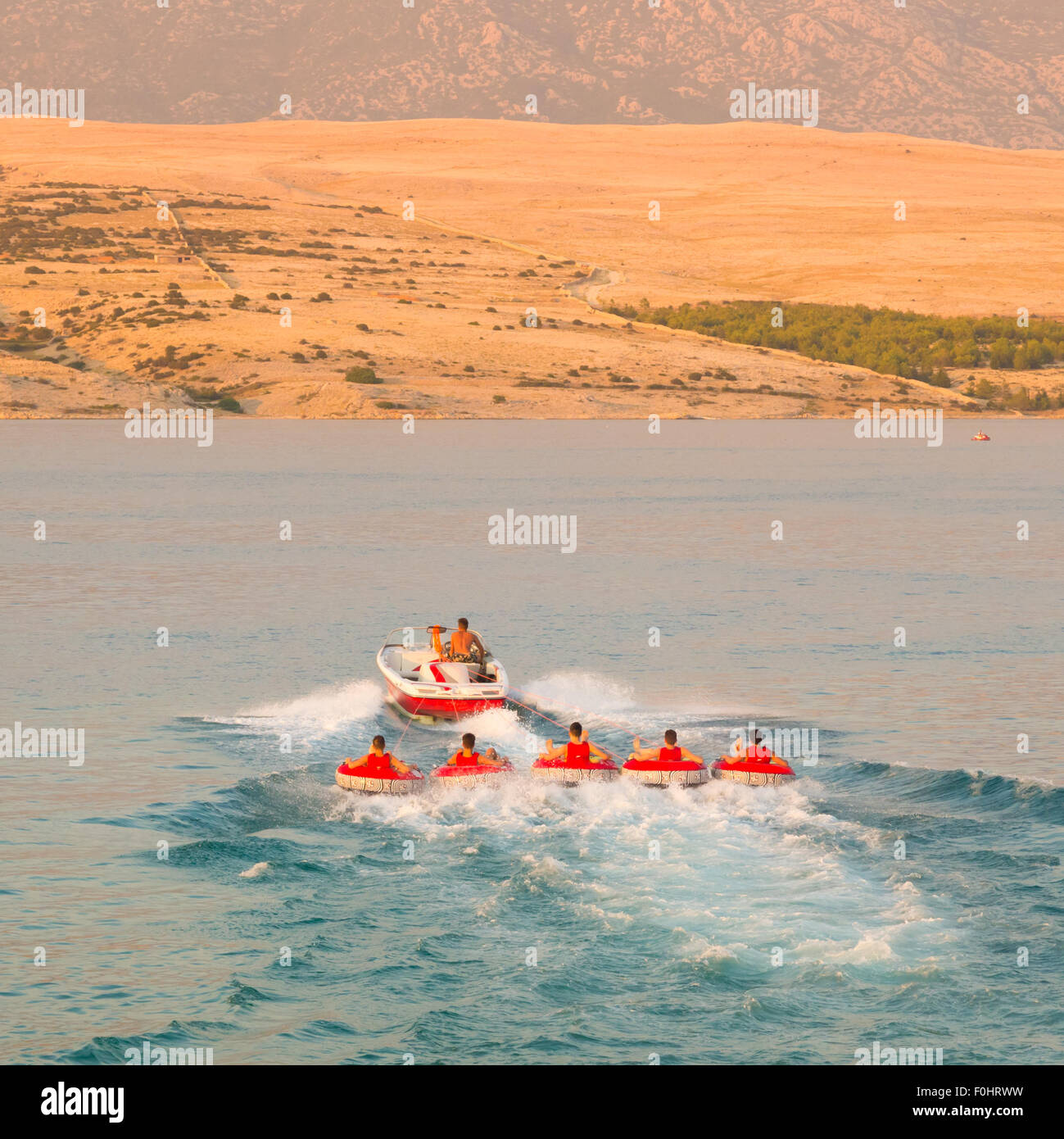 Kids tube riding tawed by speedboat Stock Photo - Alamy