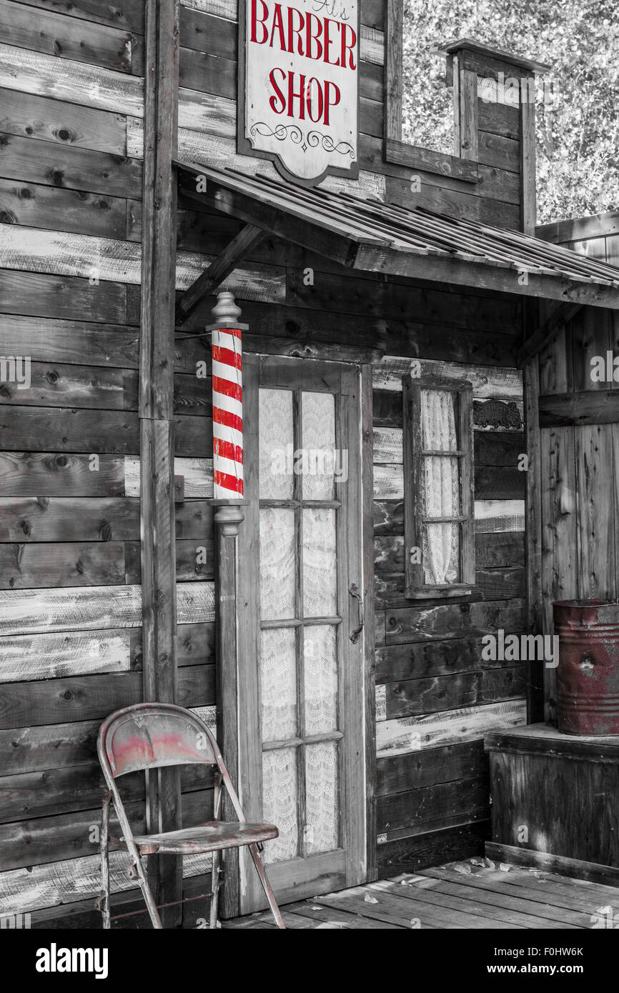 Wild west style Barbers shop exterior facade with red sign and red and ...
