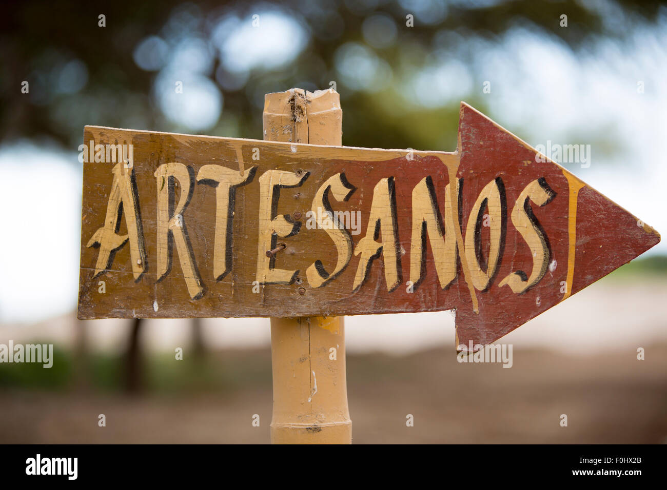 Wooden sign post with Crafts written in Spanish and blurred background ...