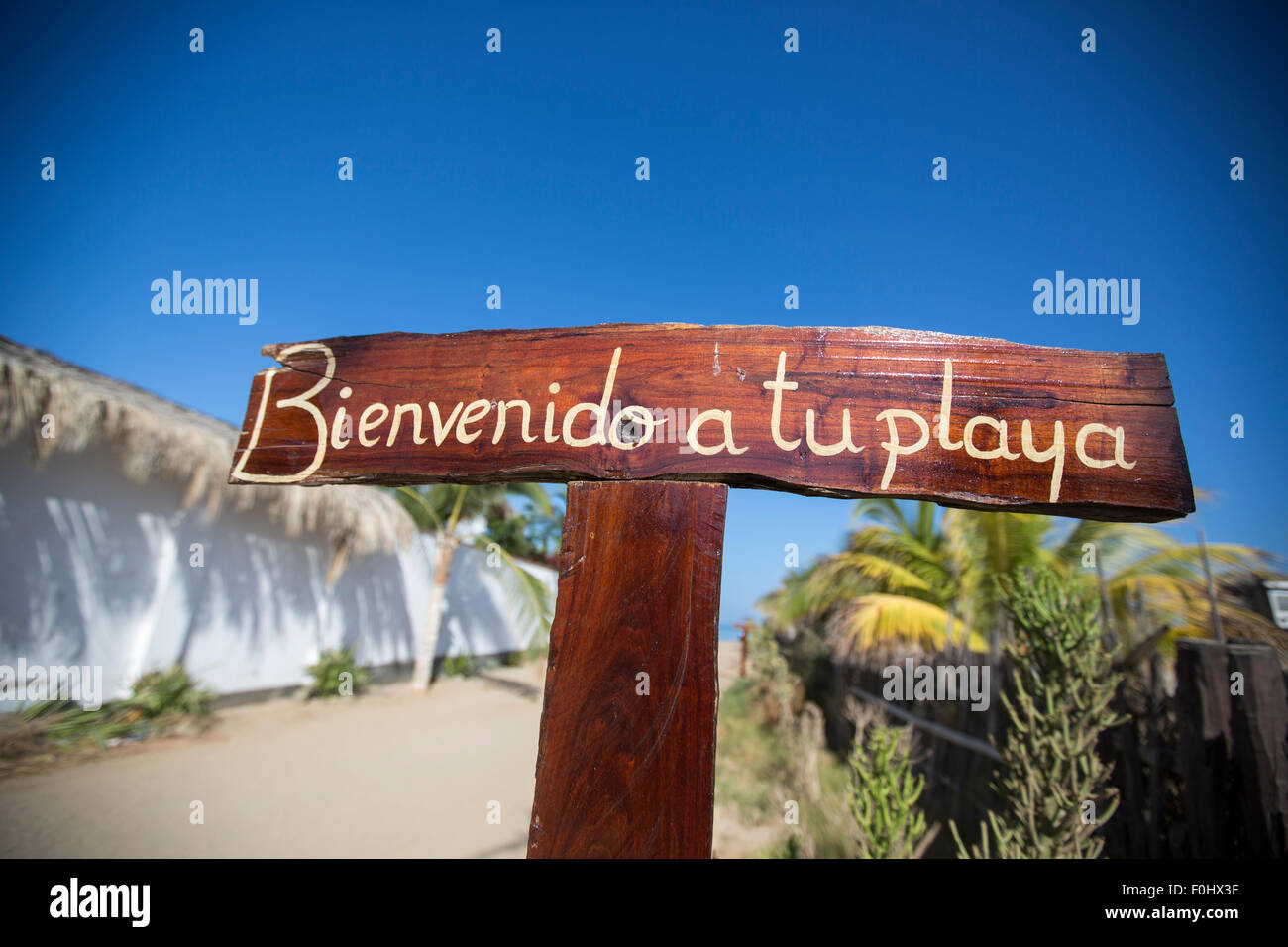 Wooden sign post saying welcome to the beach in Spanish, Mancora, Peru ...
