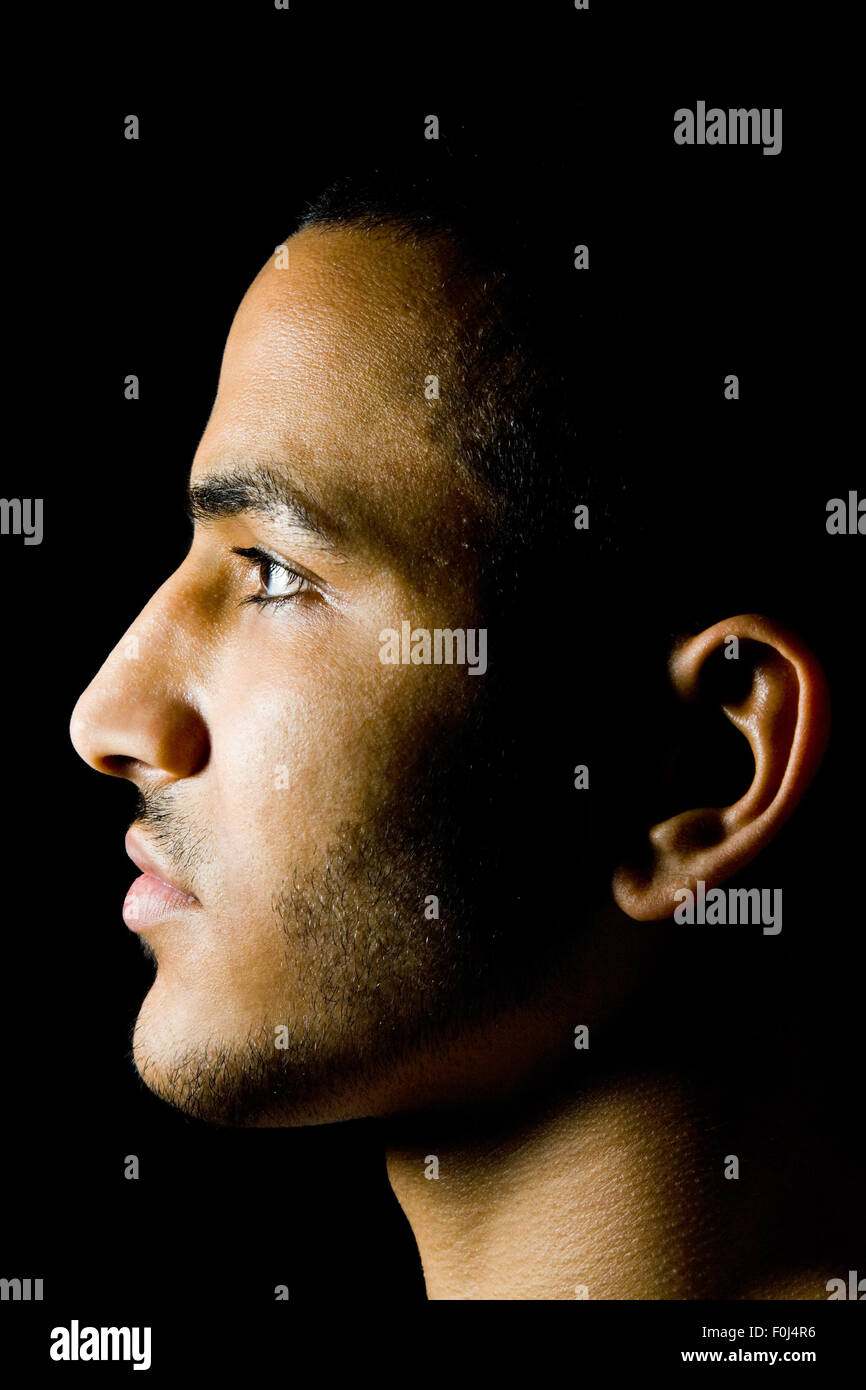Proile view of young moroccan man in the dark Stock Photo - Alamy