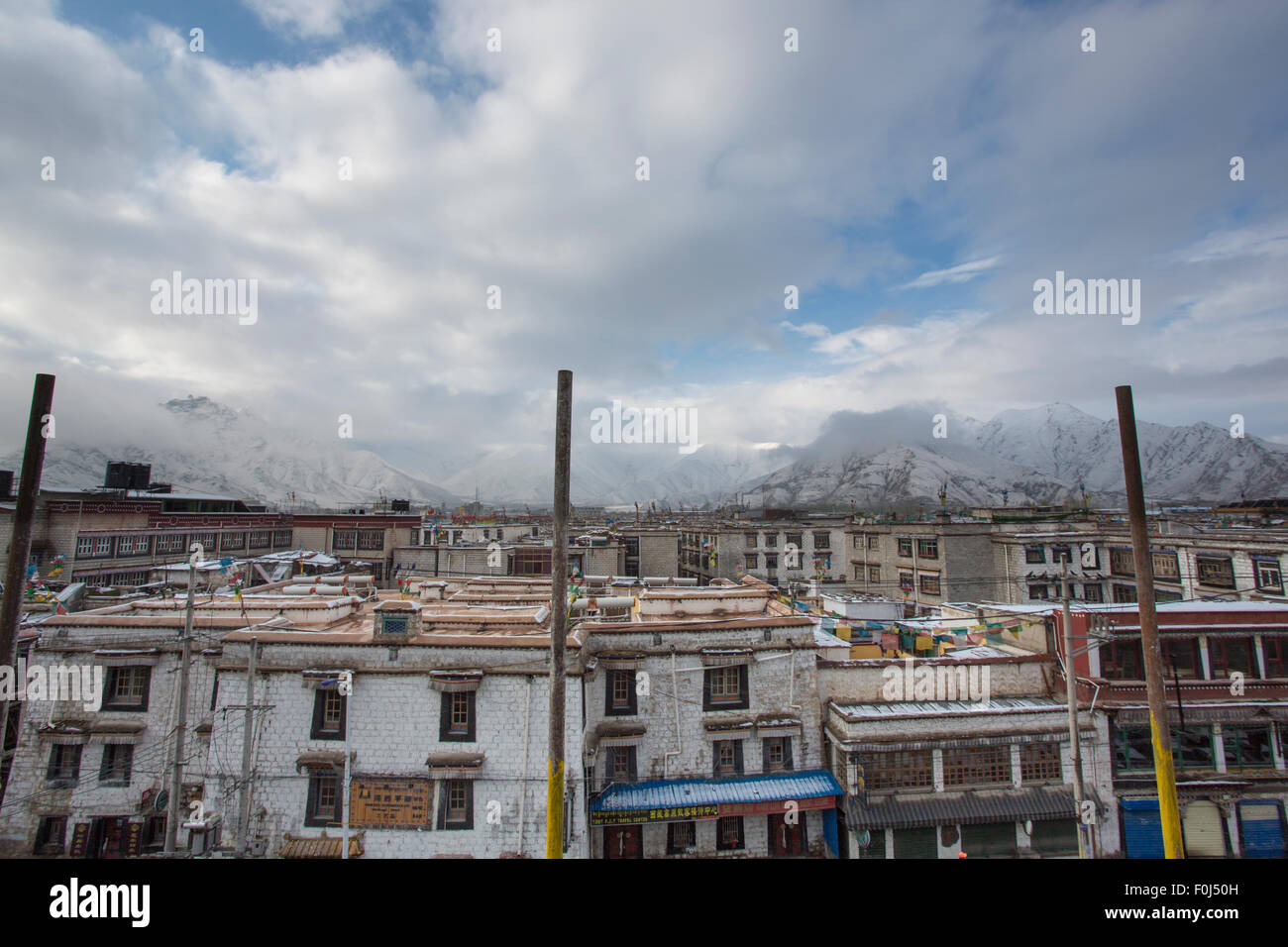 Rooftops in Lhasa and the snowy mountains early in the in the ...