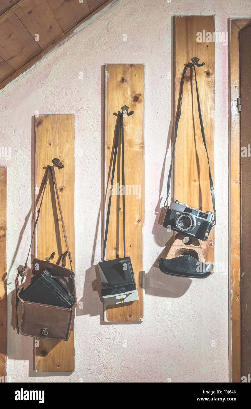 Vintage photo camera hooked on the hanger on the wall Stock Photo - Alamy