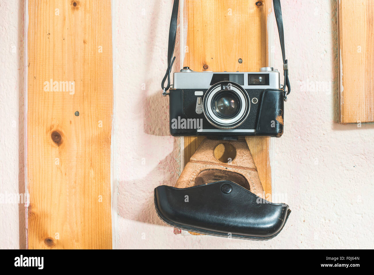 Vintage photo camera hooked on the hanger on the wall Stock Photo - Alamy