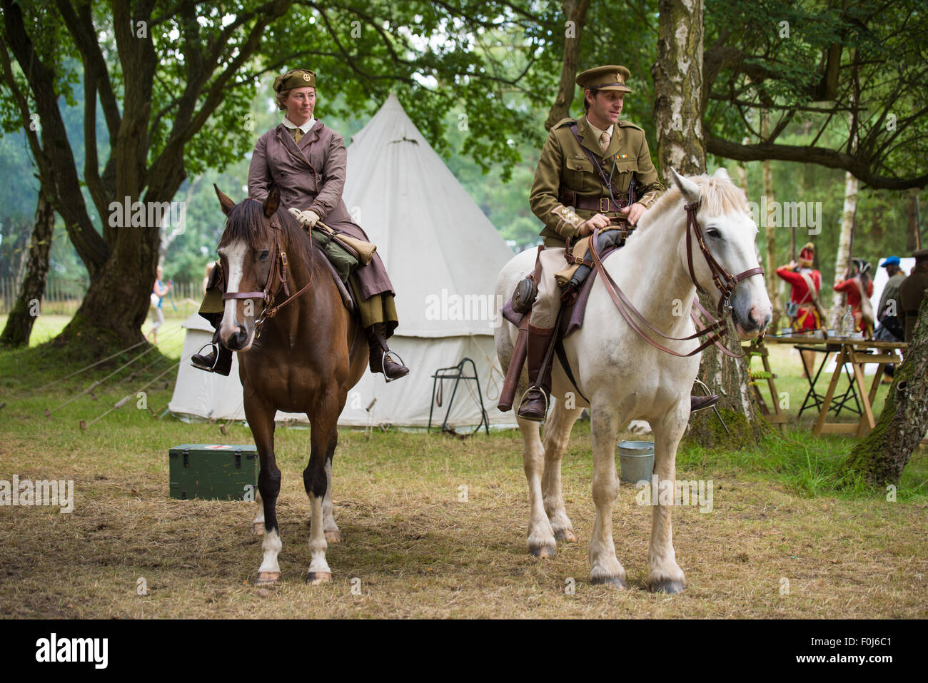 Re-enactment of WW1 soldier and female medic on horseback putting on a ...