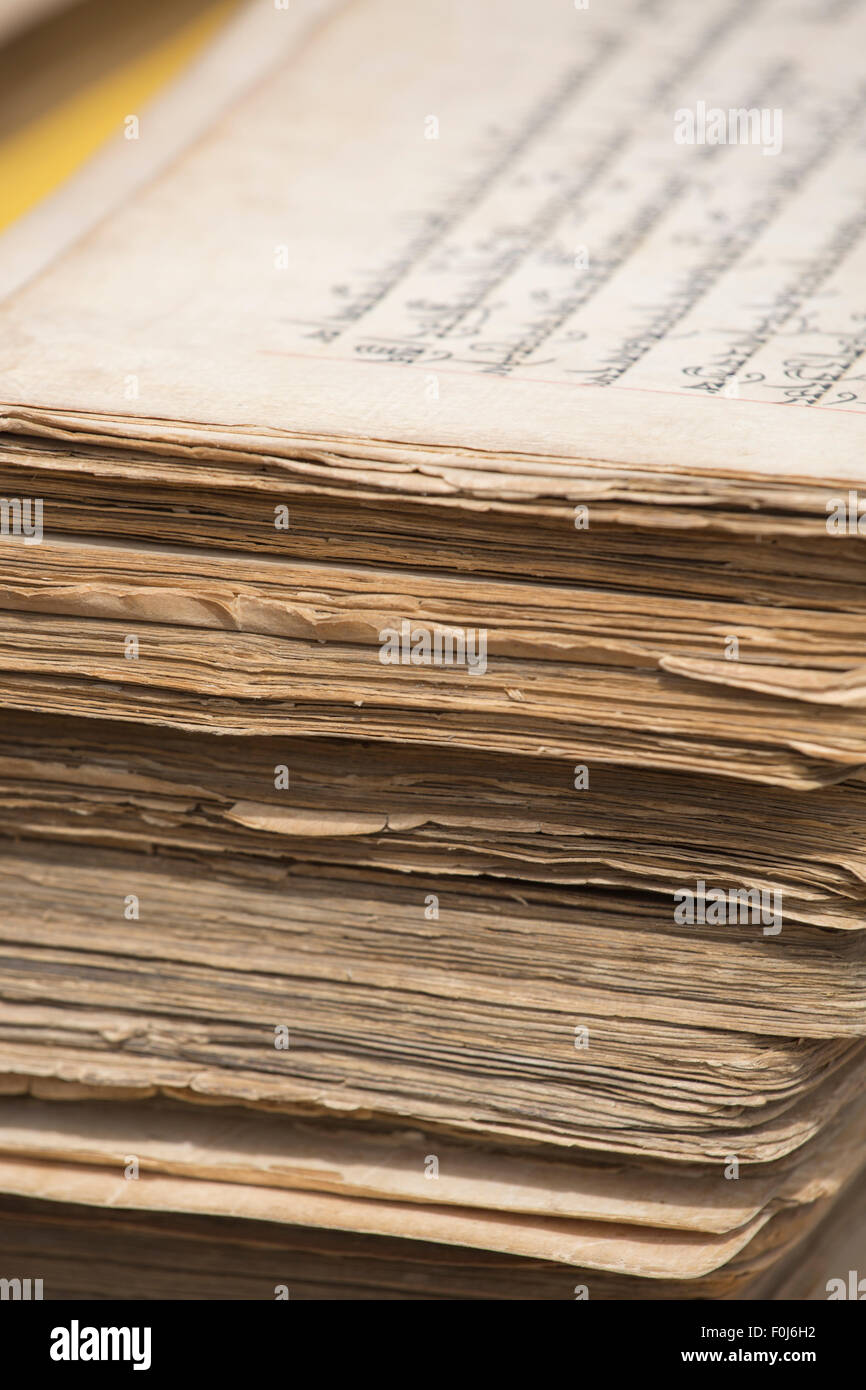 Stack of old Tibetan manuscripts under consideration in a temple in ...