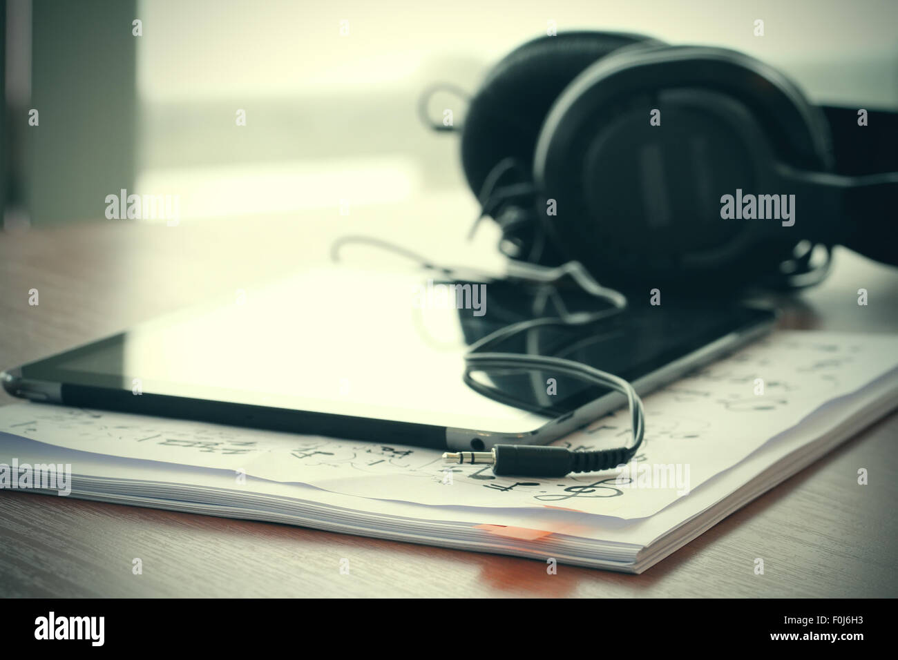 Closeup jack of smart phone with headphone on musical notes paper with ...