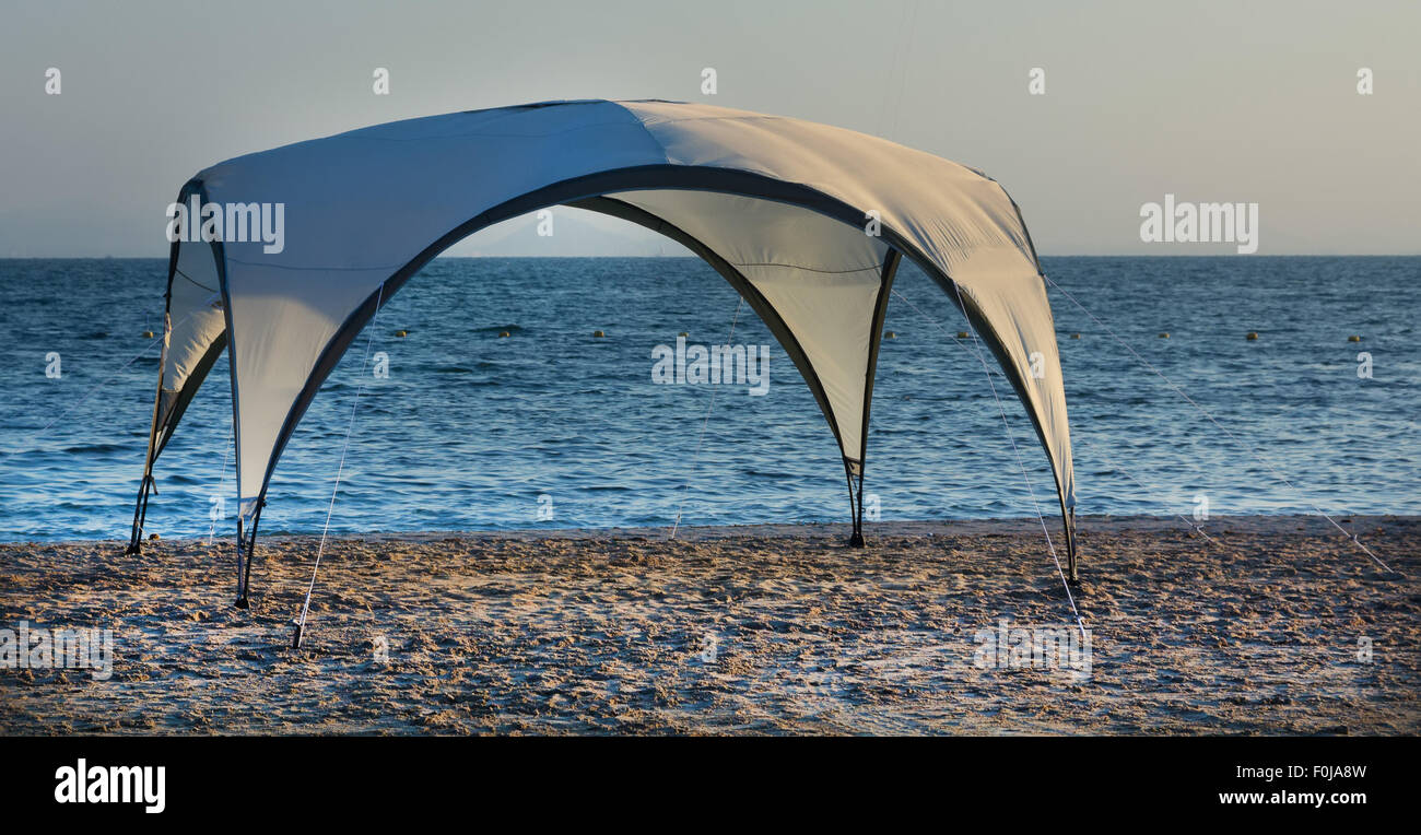 Modern parasol with four legs on the beach Stock Photo - Alamy