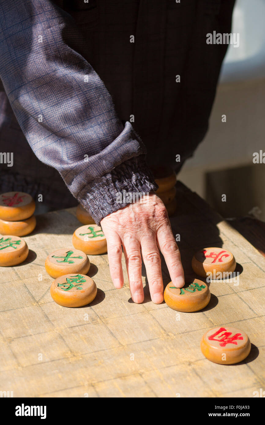 Close up of hand of old man playing a traditional Chinese game ...