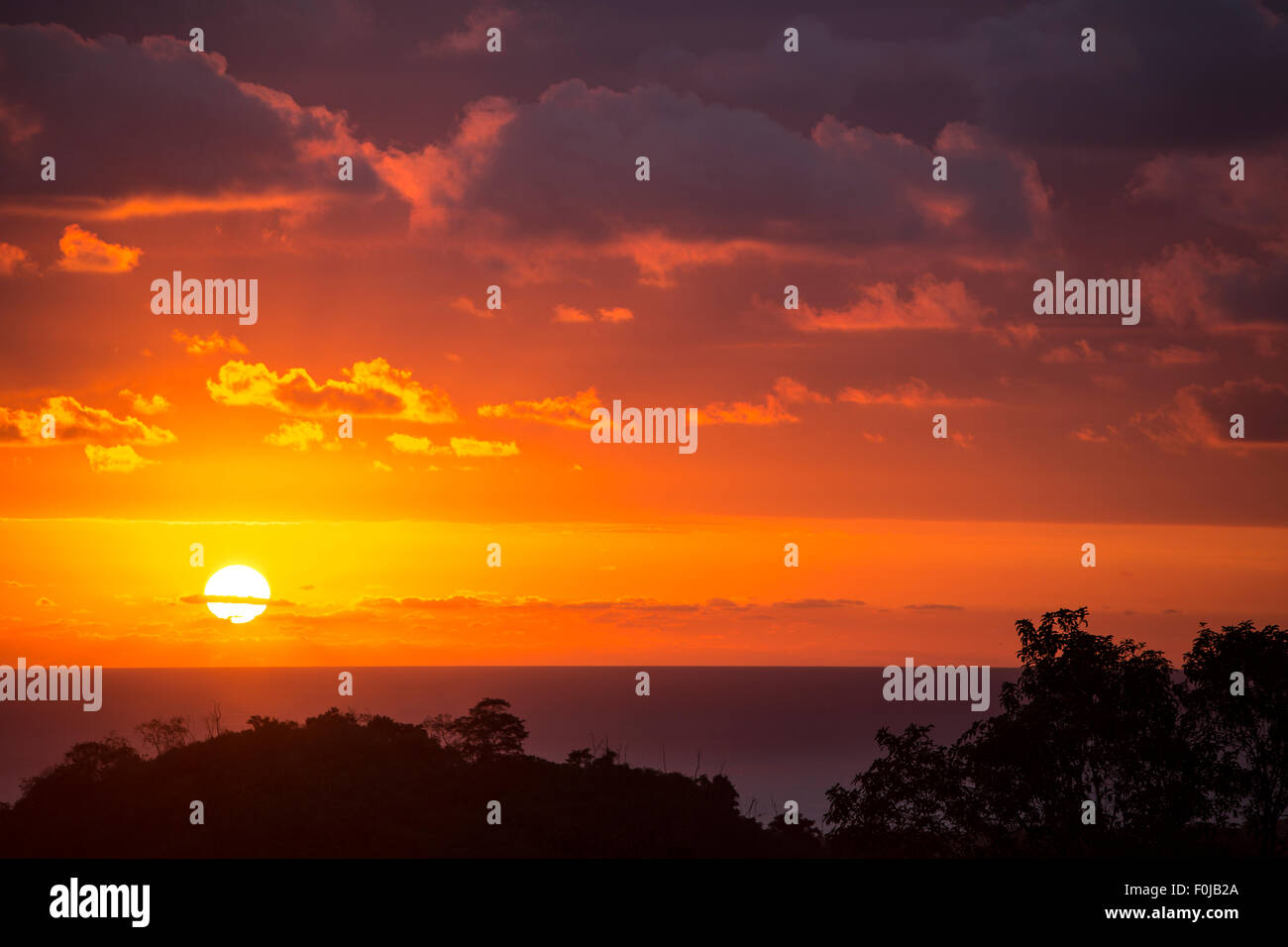 Dramatic sunset sun in clouds seen from the beach of Matapalo, Costa ...