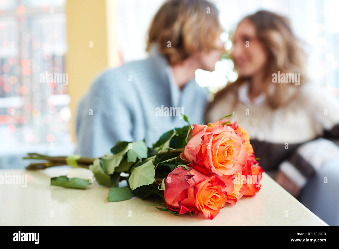 Bouquet of red roses on background of young romantic couple Stock Photo ...