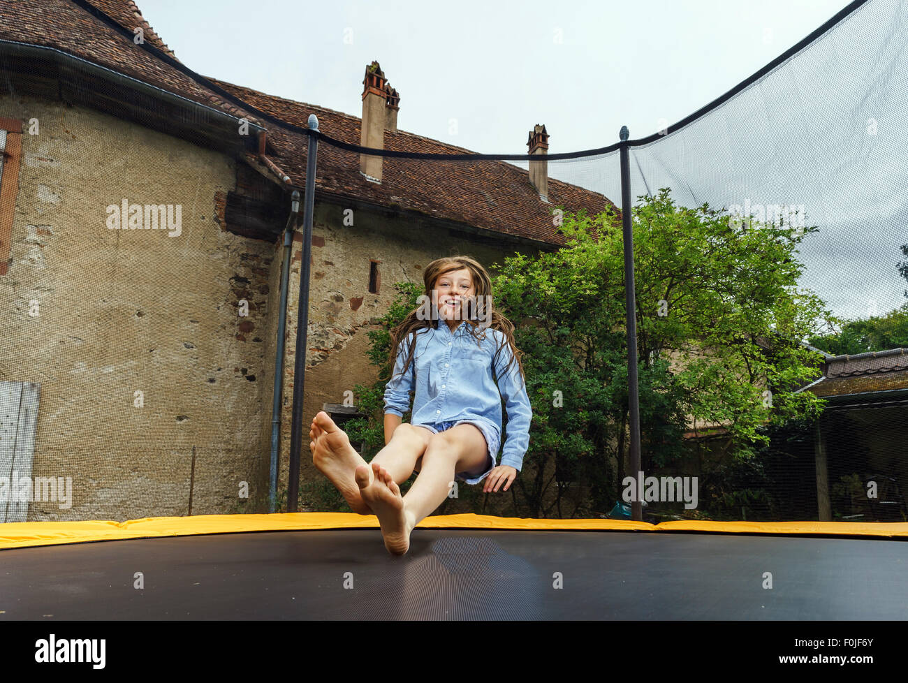 Cute teenage girl jumping on trampoline, childhood concept Stock Photo ...