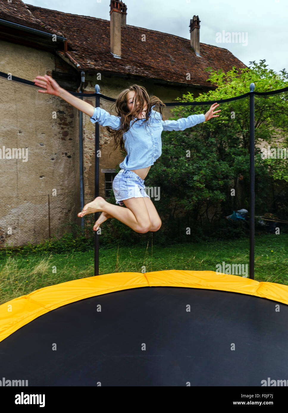 Cute teenage girl jumping on trampoline, childhood concept Stock Photo ...