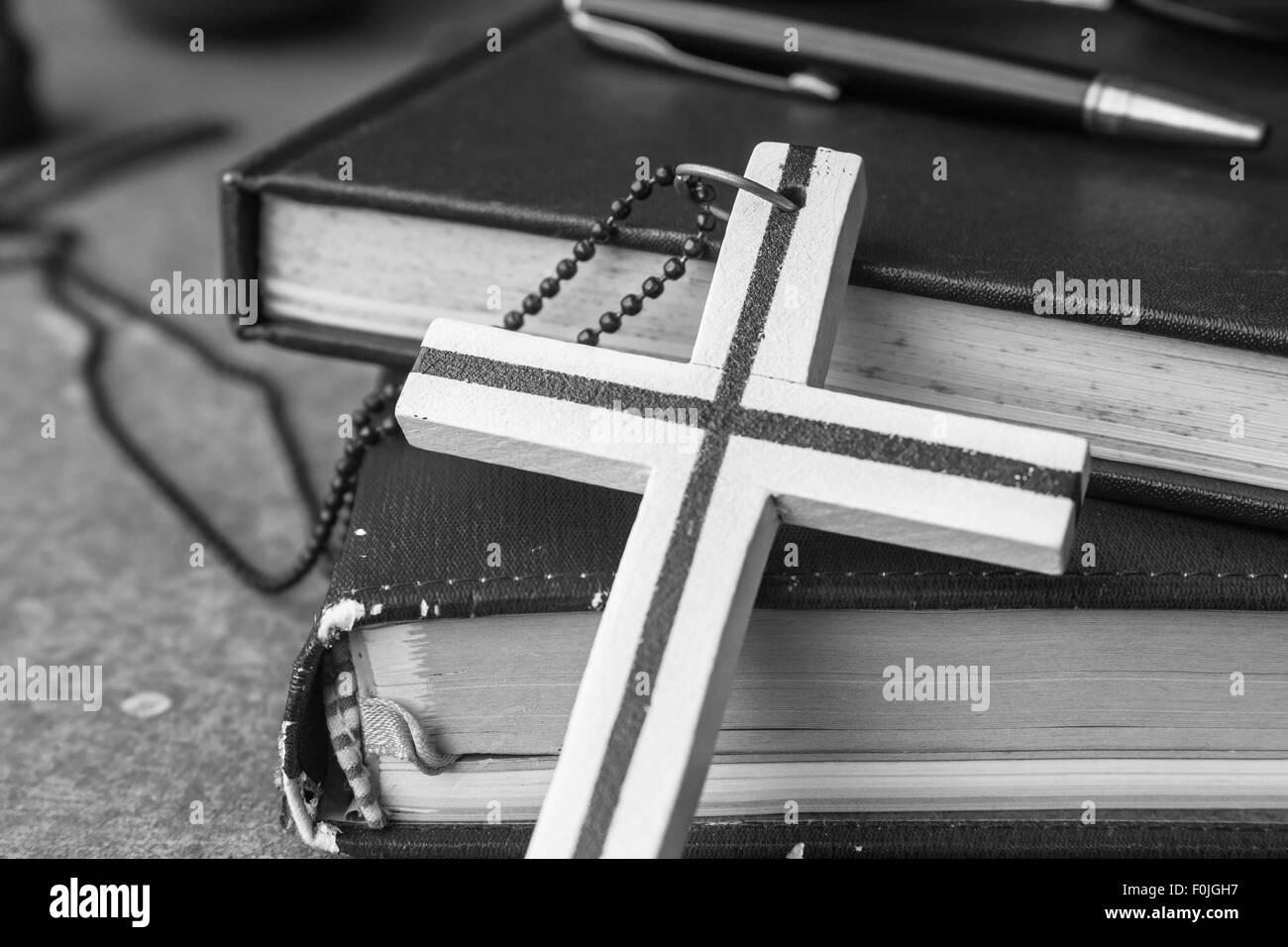 Cross placed leaning against an old book with the black and white Stock ...