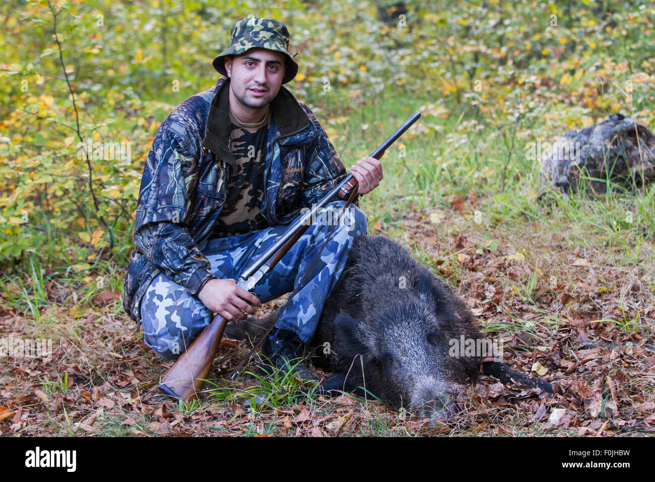 Young Romanian hunter posing with his first Wild boar (Sus scrofa) that ...