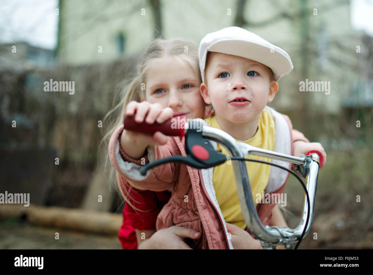 children ride on bicycle in yard Stock Photo - Alamy