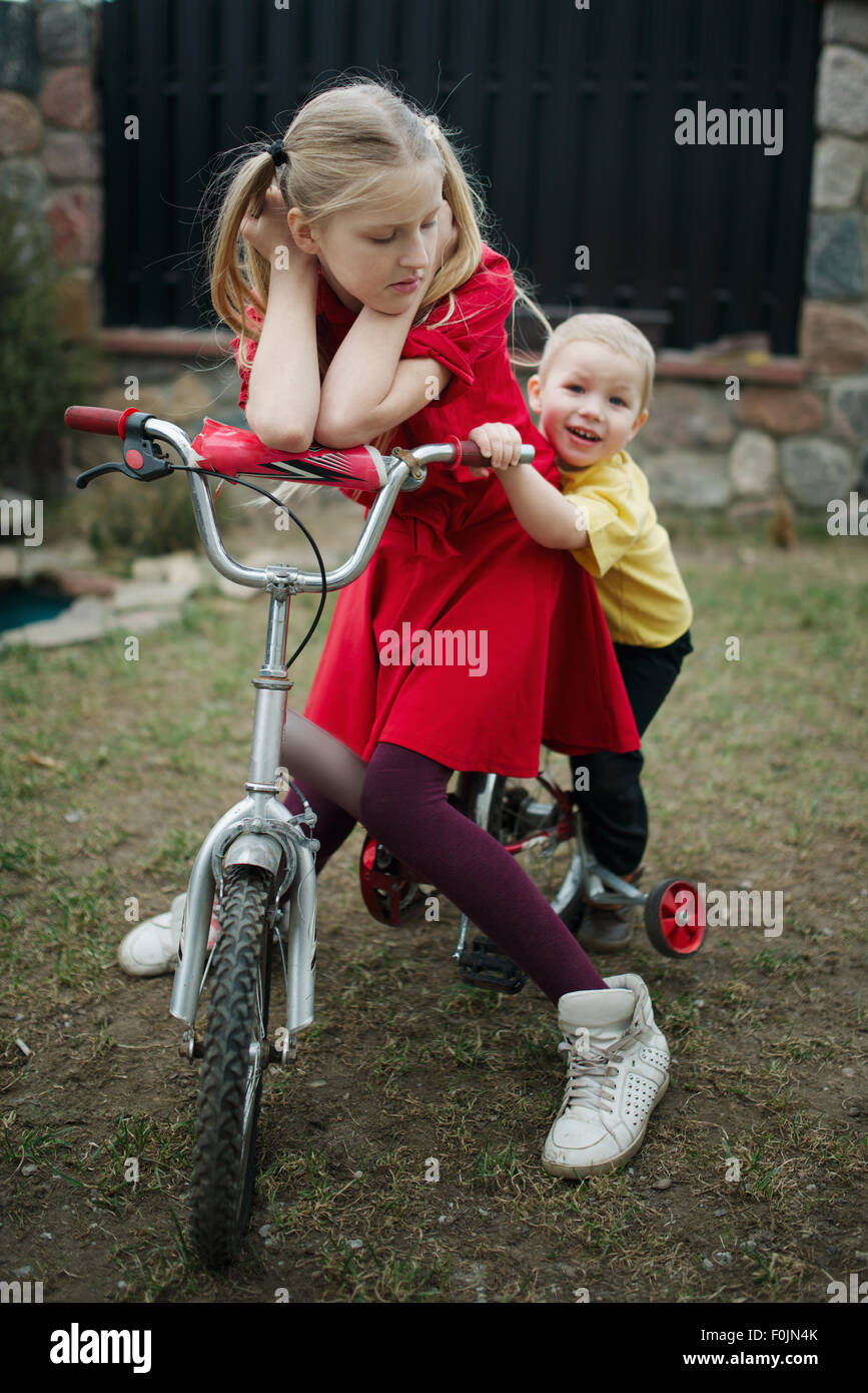 children ride on bicycle in yard Stock Photo - Alamy