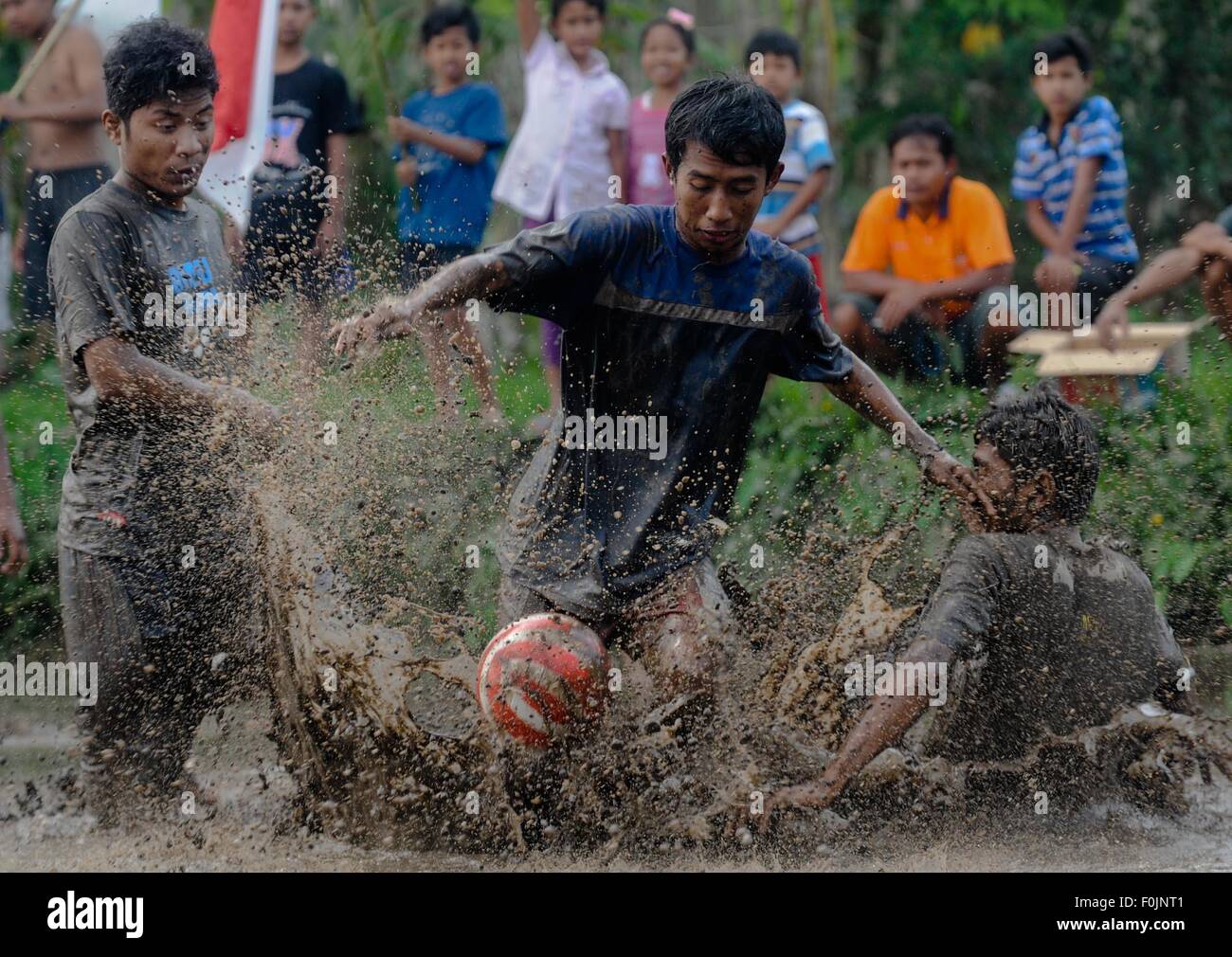 Yogyakarta, Indonesia. 17th Aug, 2015. People play football in the mud ...