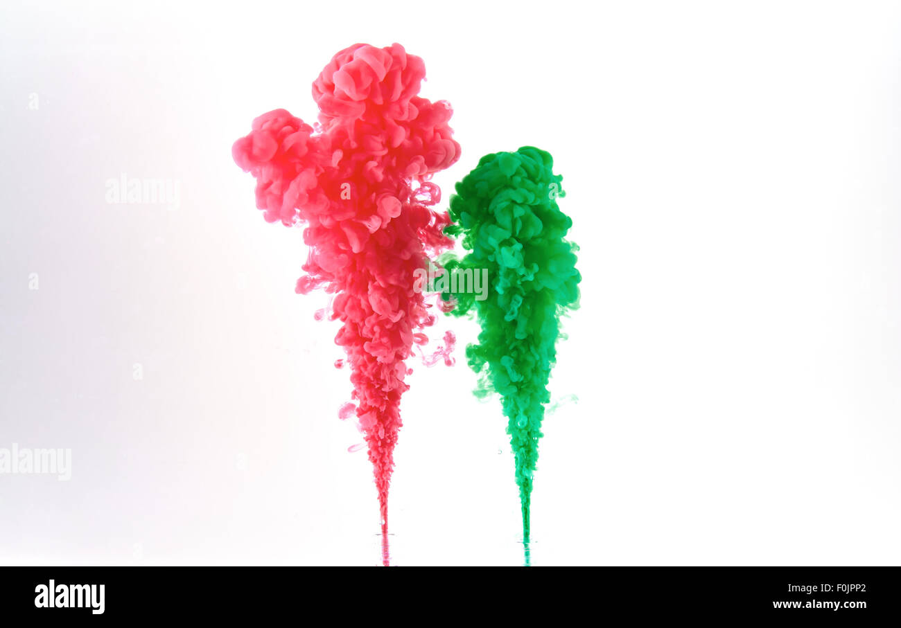 Red and green ink making clouds in water Stock Photo - Alamy